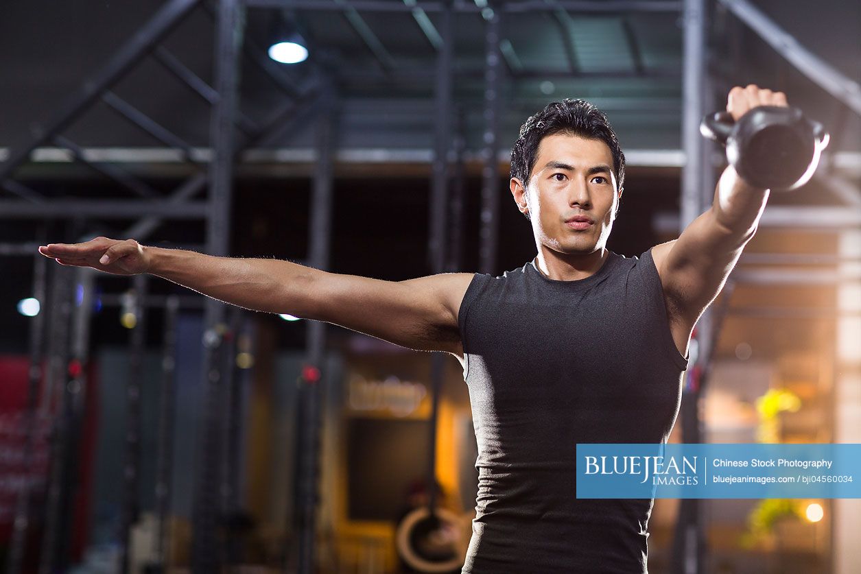 Young Chinese man training with kettlebell in crossfit gym-High-res ...