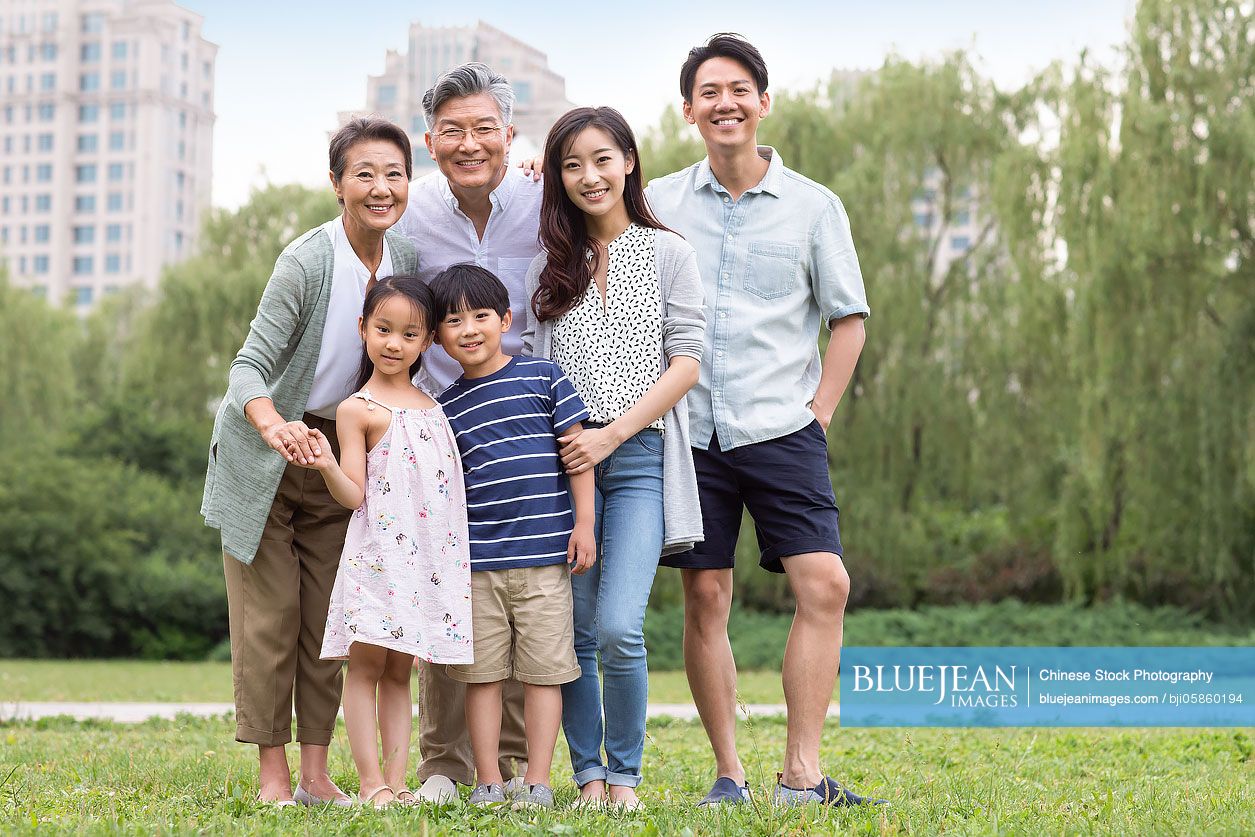 Happy Chinese family standing on grass-High-res stock photo for download