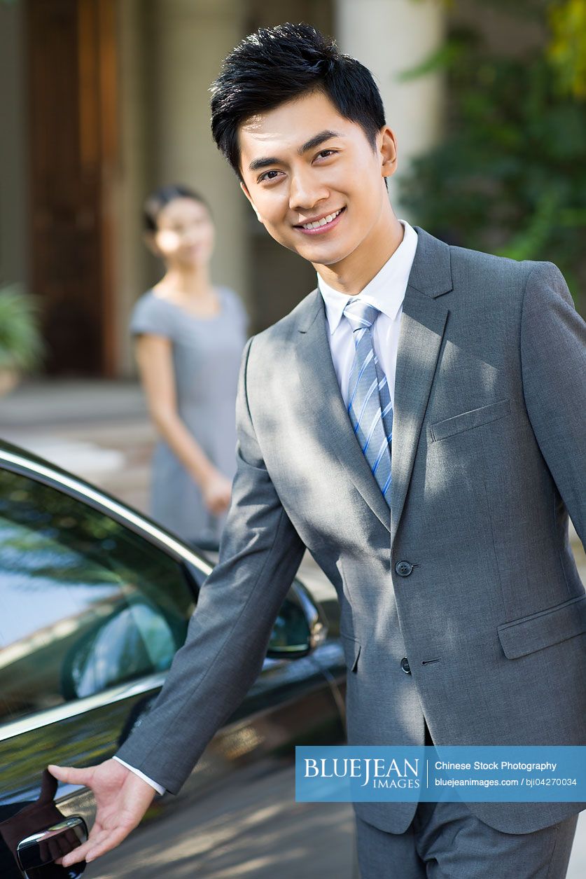 Young Chinese businessman opening car door-High-res stock photo for ...