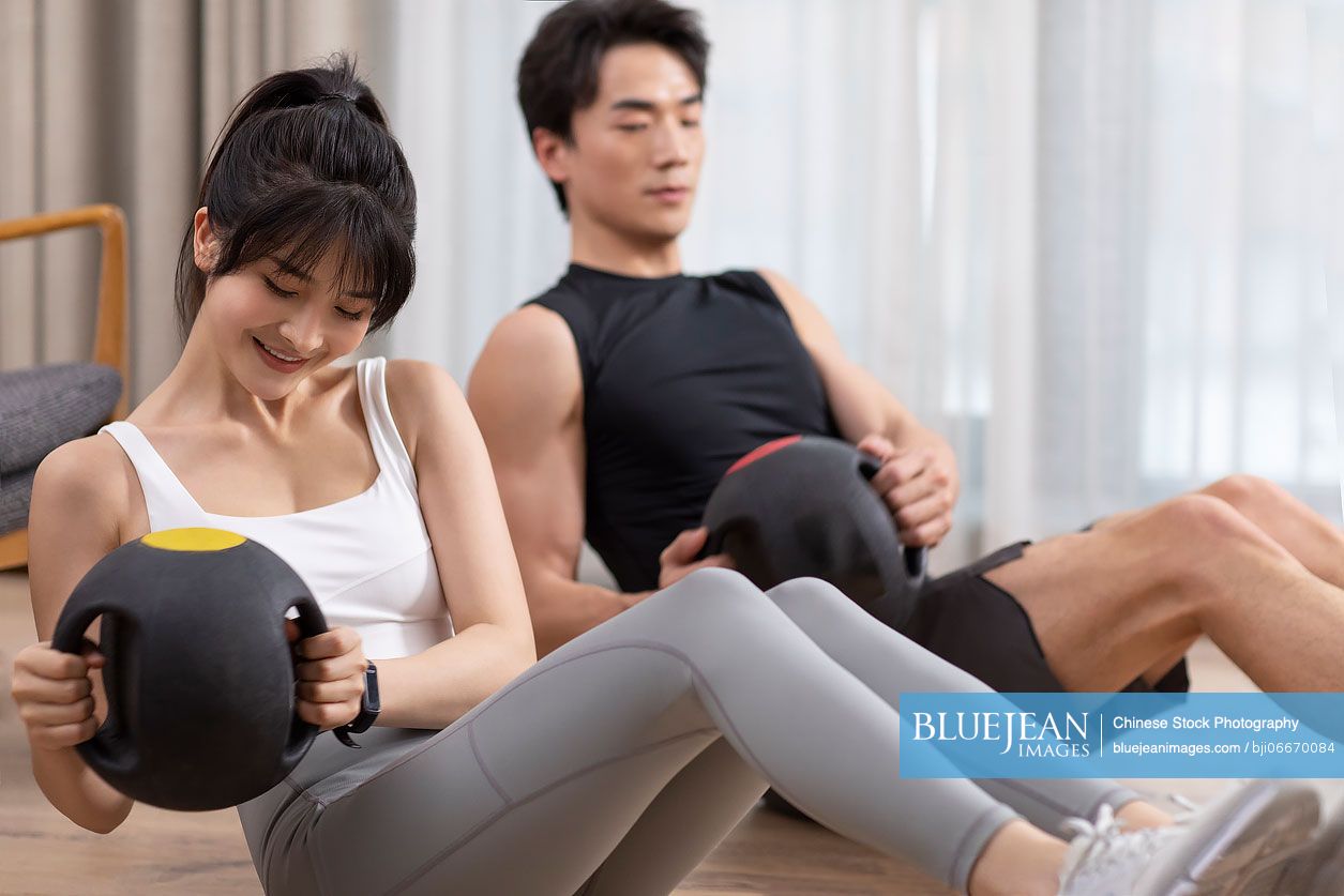 Young Chinese couple exercising at home-High-res stock photo for download