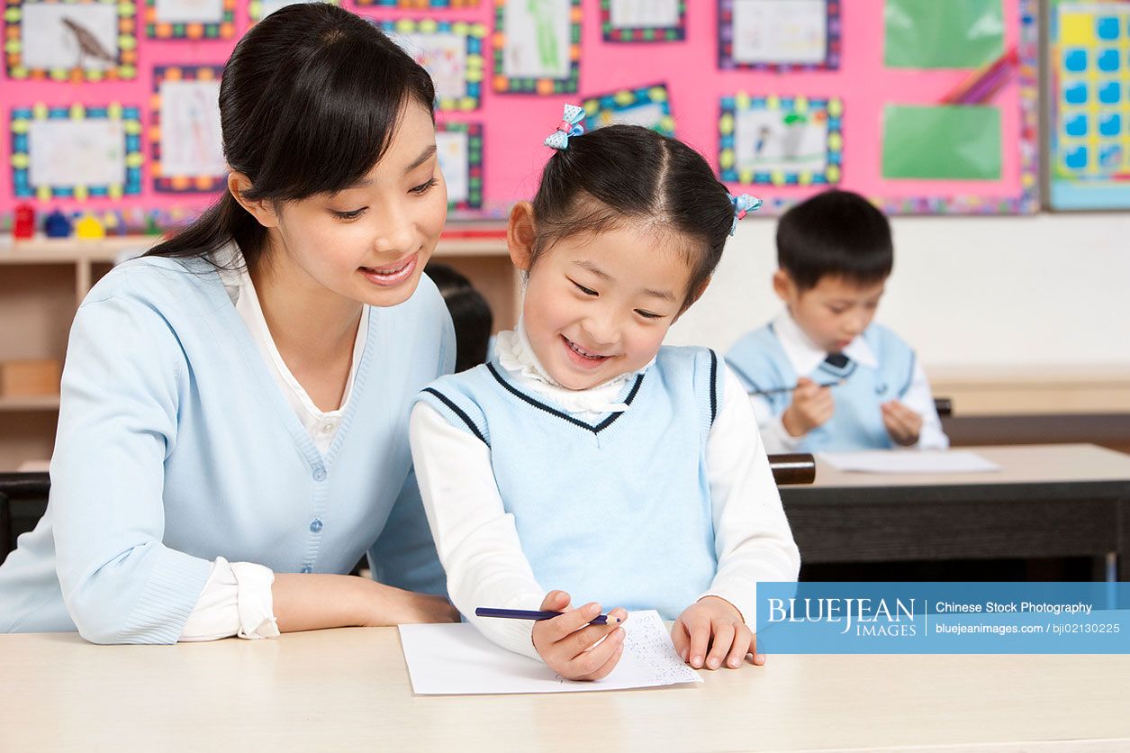 Chinese teacher assisting student in class-High-res stock photo for ...