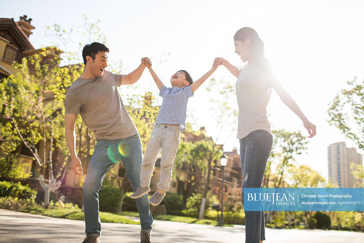 Happy young Chinese family playing outdoors-High-res stock photo for ...