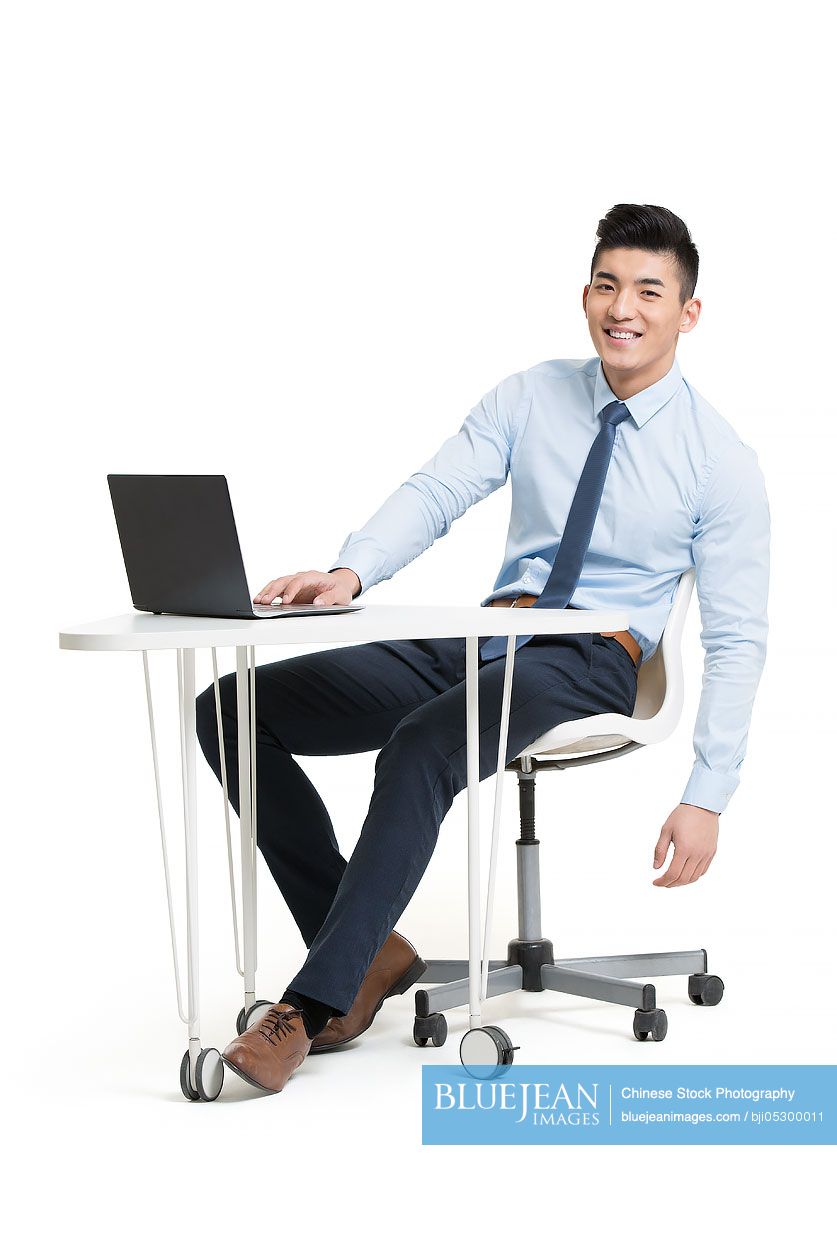 Young Chinese businessman using laptop at work-High-res stock photo for download