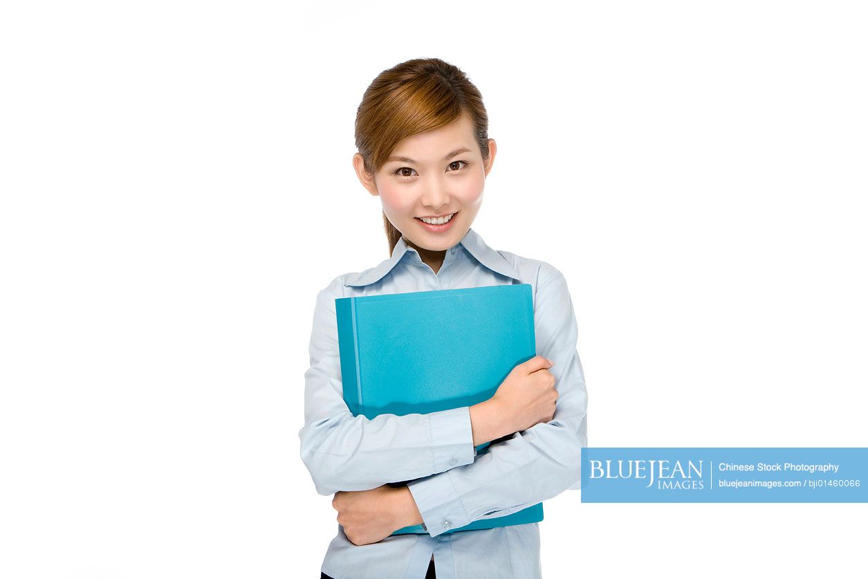 Smiling young Chinese businesswoman holding file folder-High-res stock ...