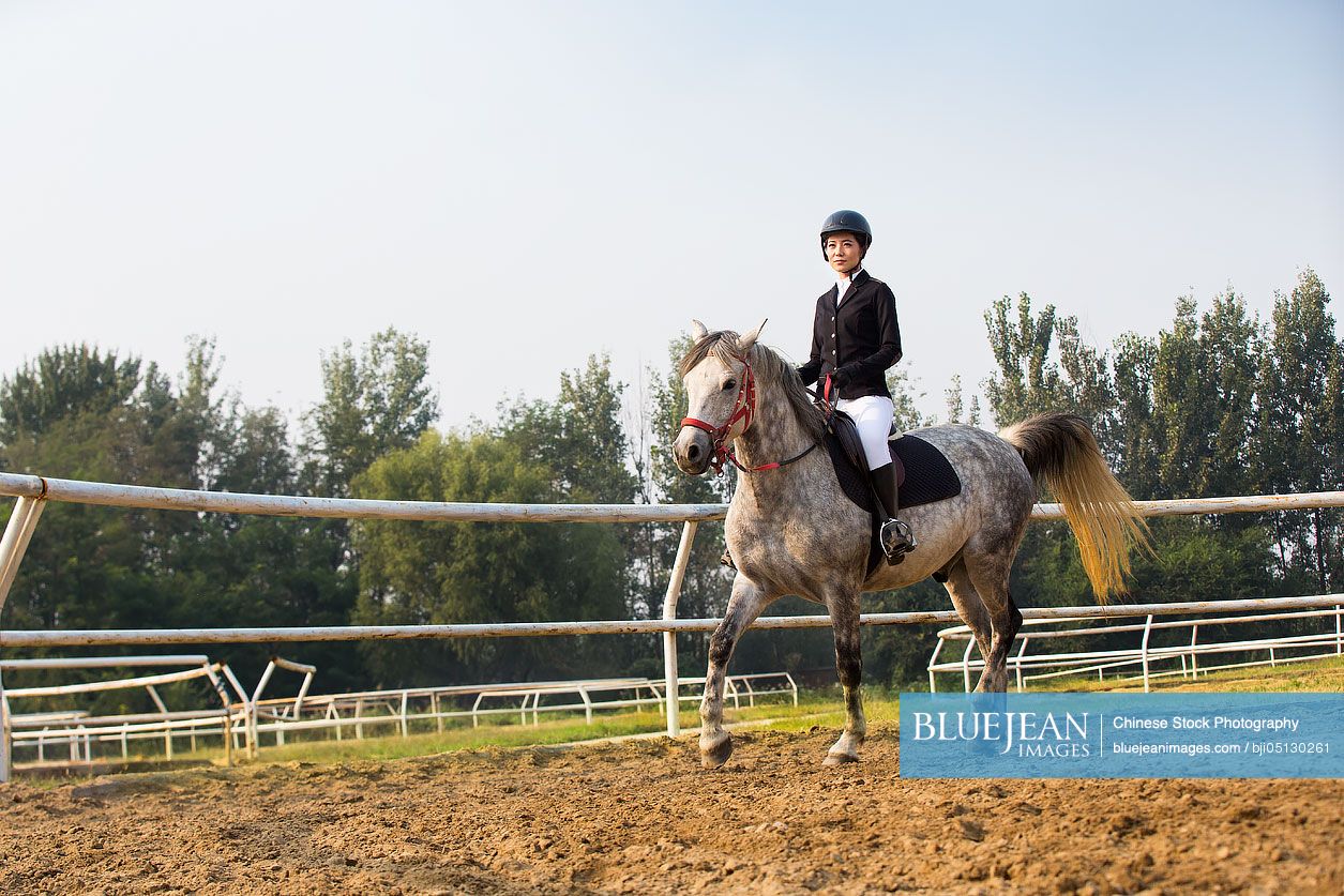 Young Chinese woman riding horse-High-res stock photo for download
