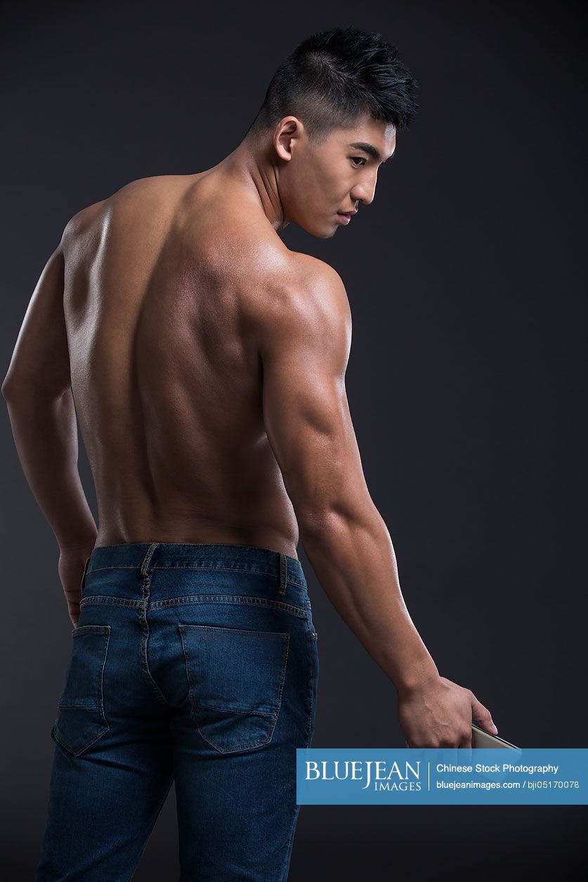 Young Chinese muscular man with a smart phone-High-res stock photo for ...