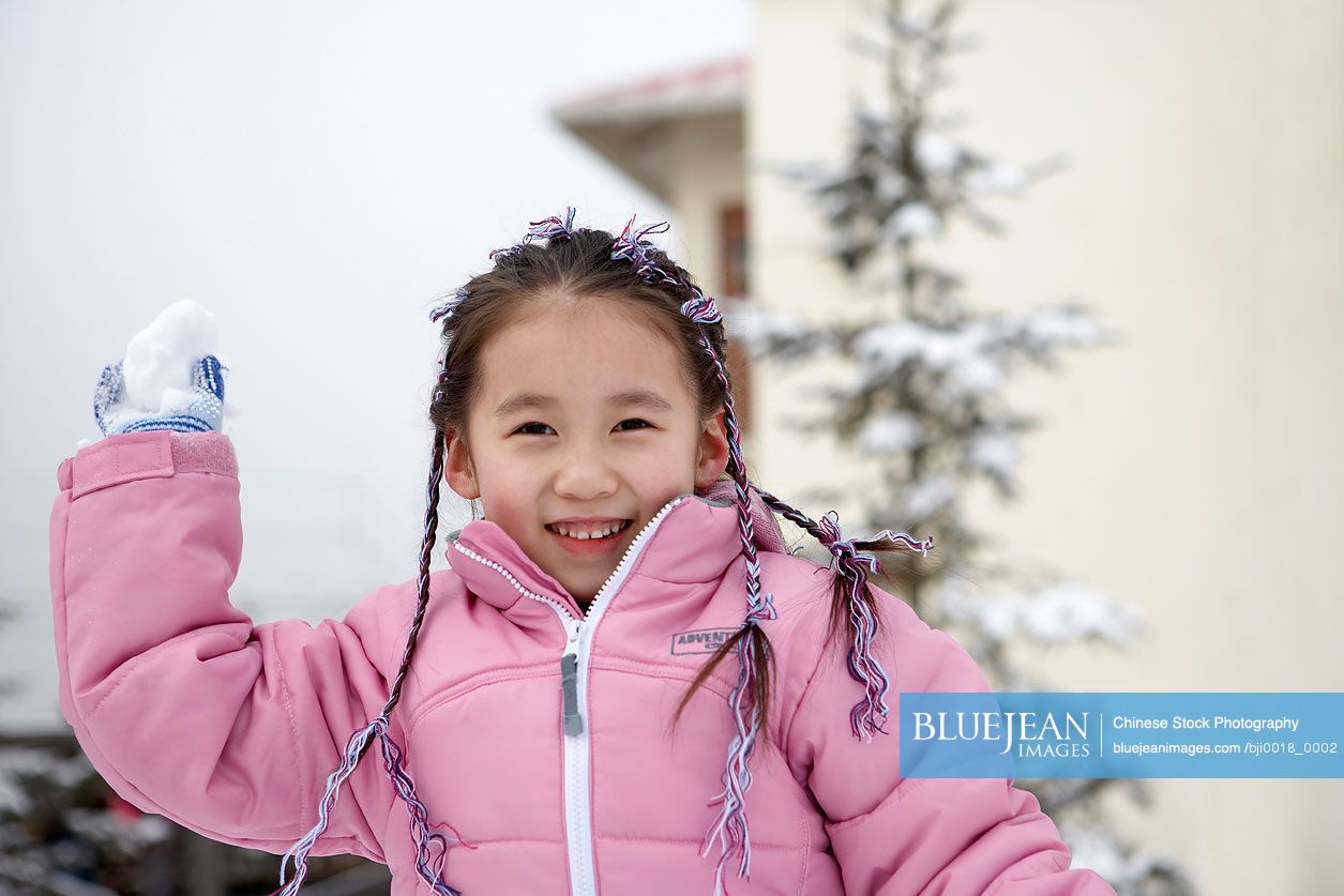 Young Chinese girl throwing snowball-High-res stock photo for download