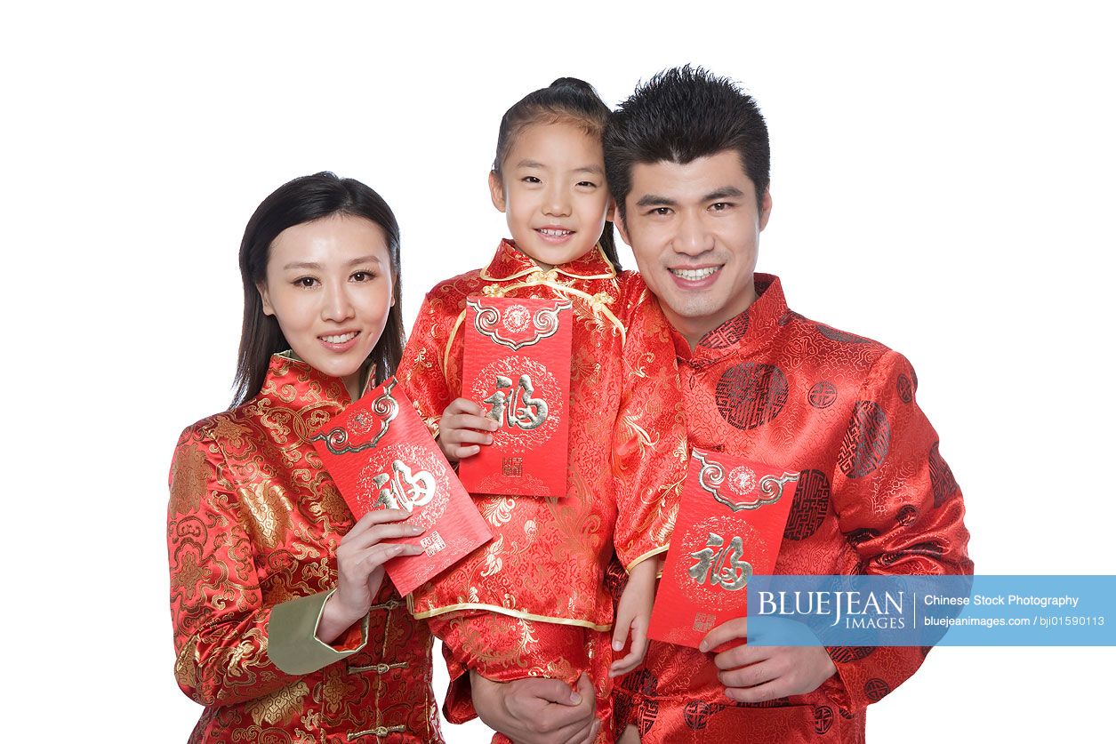 Family of three in Chinese traditional clothes holding red envelopes ...