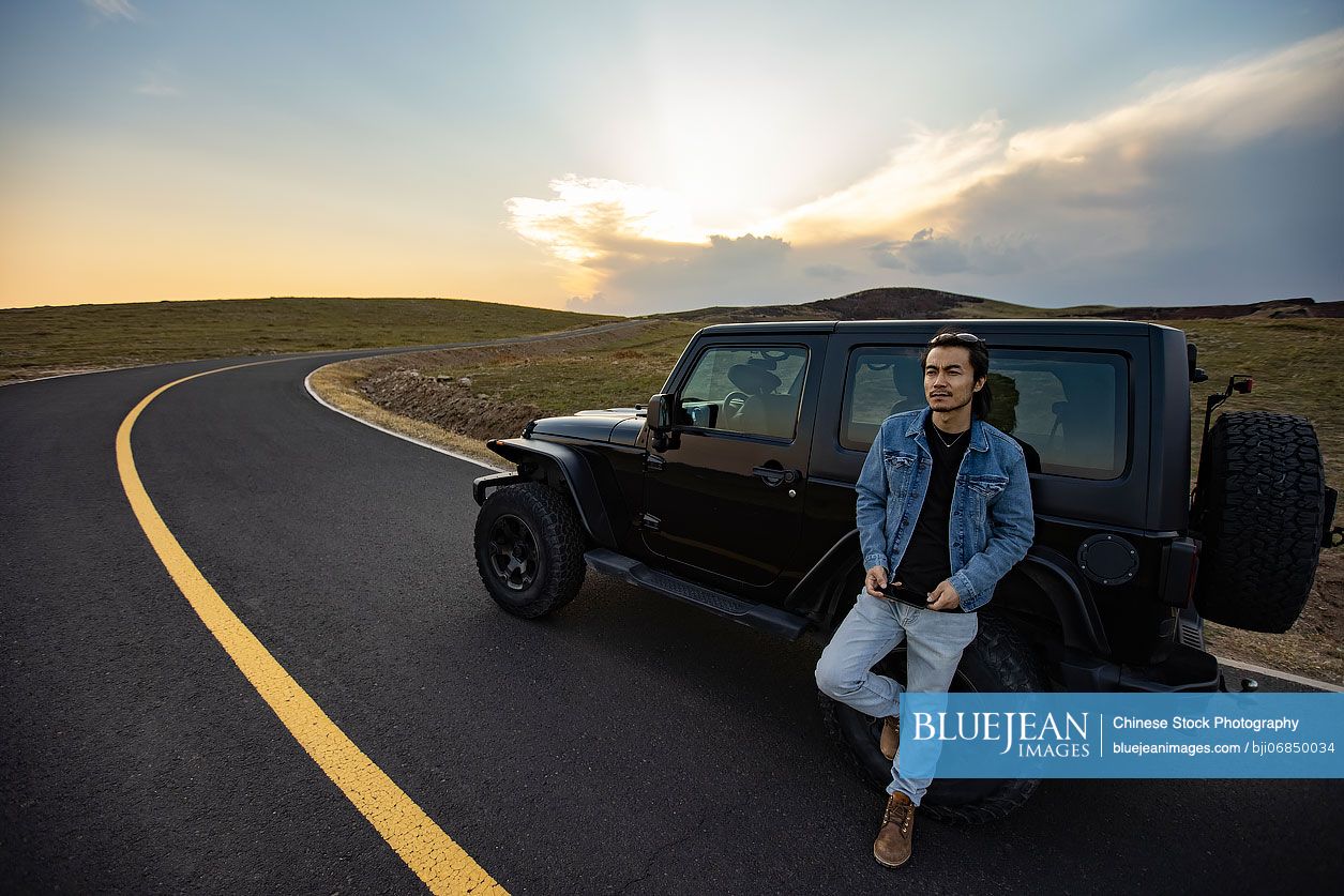 Happy Chinese mid adult man enjoying road trip-High-res stock photo for download