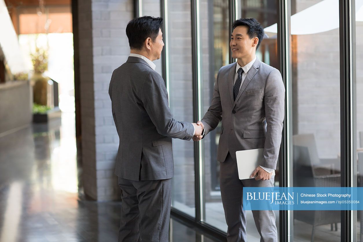 Cheerful Chinese businessmen shaking hands-High-res stock photo for ...