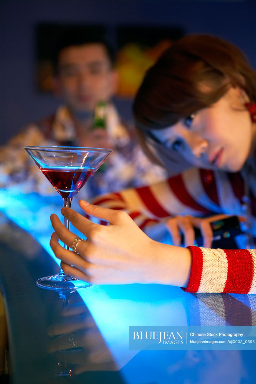 Chinese woman drinking cocktail at bar-High-res stock photo for download