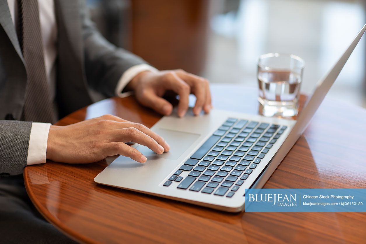 Confident Chinese businessman using laptop-High-res stock photo for download