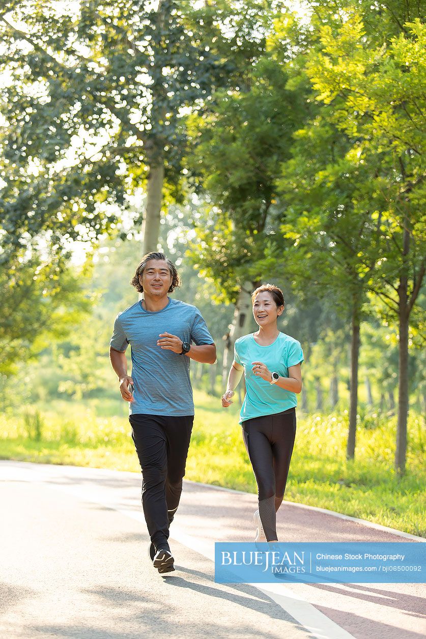 Happy mature Chinese couple running in park-High-res stock photo for download