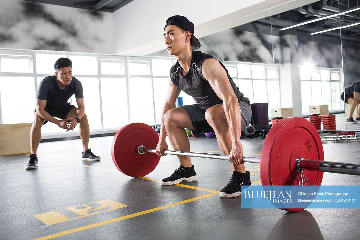 Young Chinese man working with trainer at gym-High-res stock photo for ...