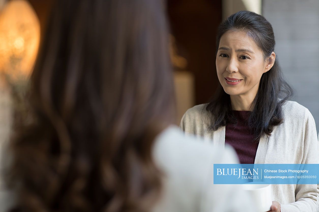 Elegant mature Chinese woman talking with young woman-High-res stock ...