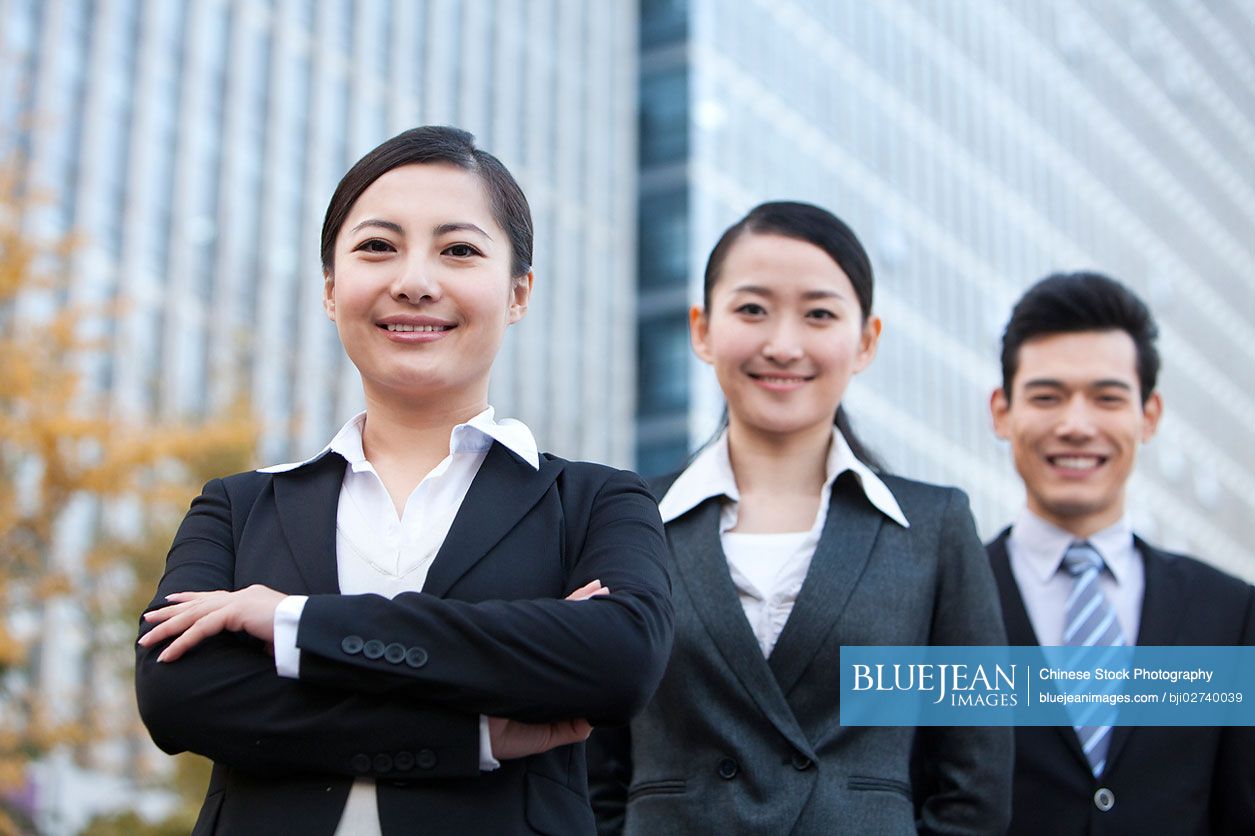 A team of Chinese businesspeople outside office buildings-High-res ...