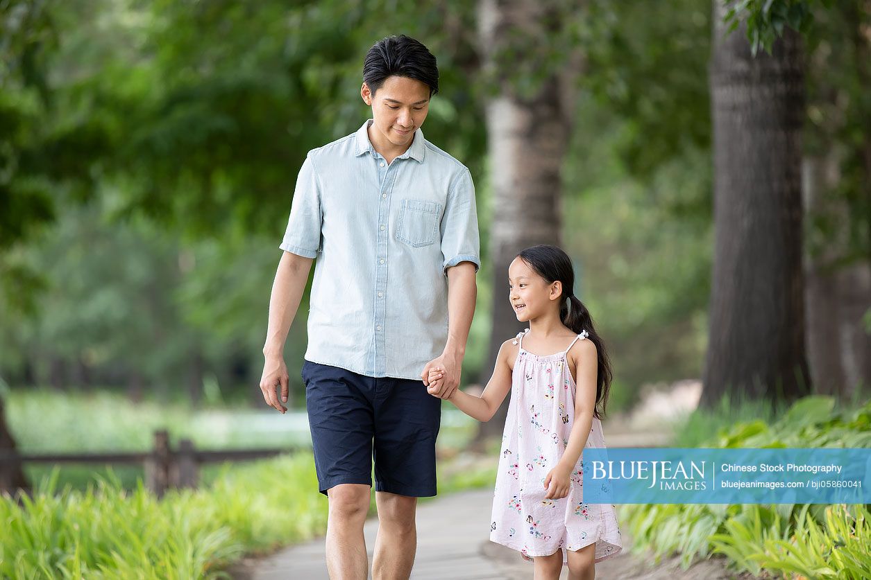 Happy Chinese father and daughter walking in park-High-res stock photo ...