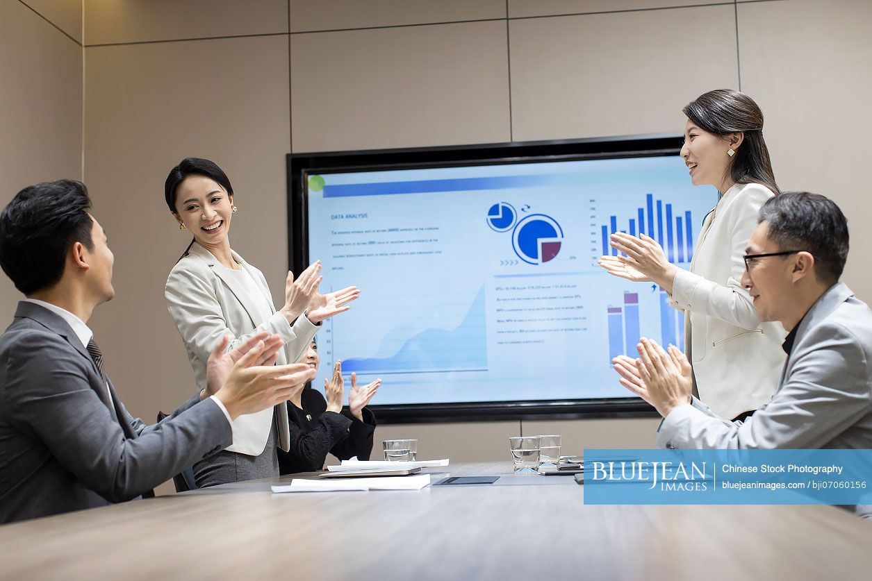 Cheerful Chinese business people applauding in meeting room-High-res ...