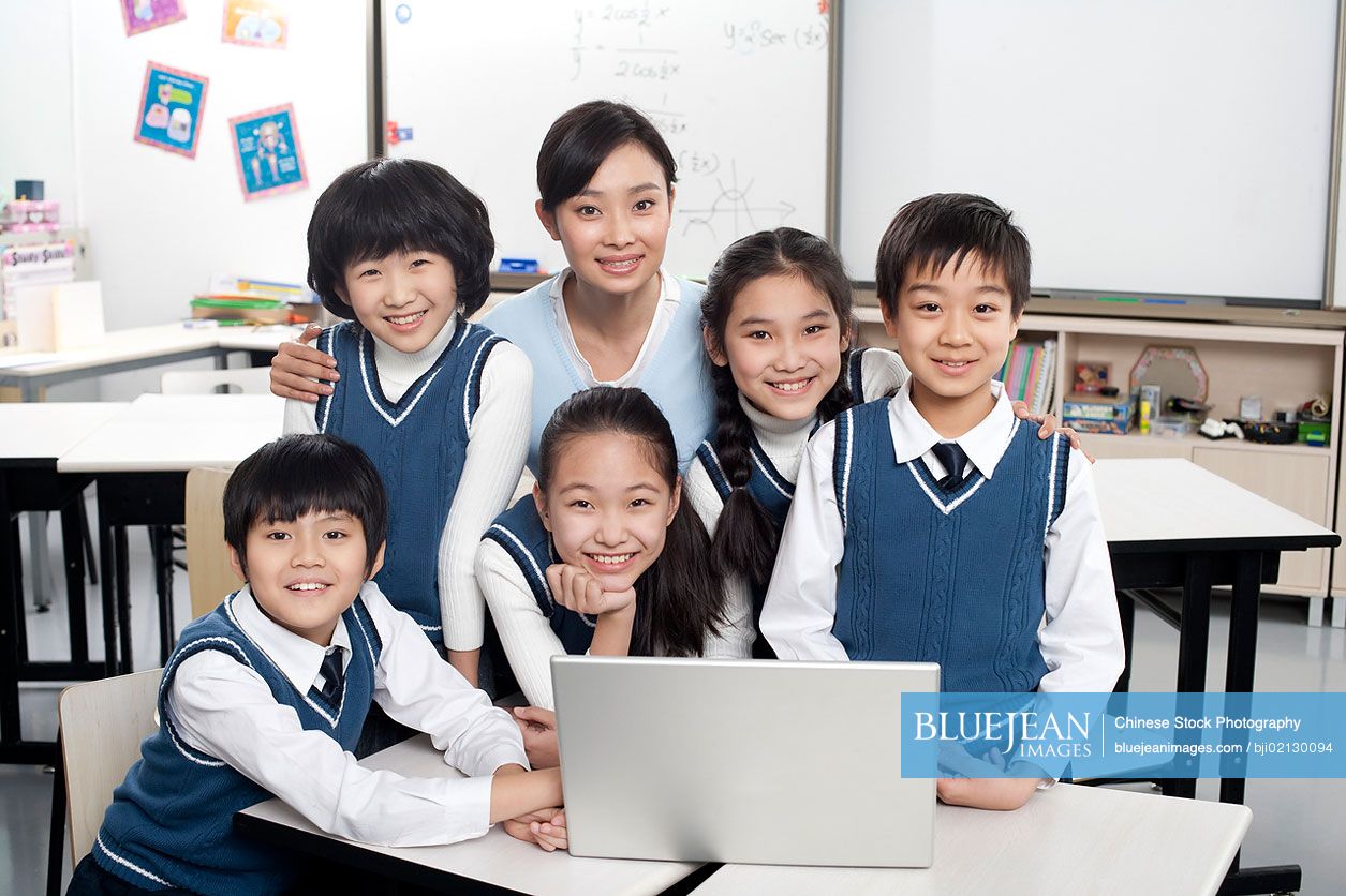 Chinese students and teacher gathered around a computer in the ...