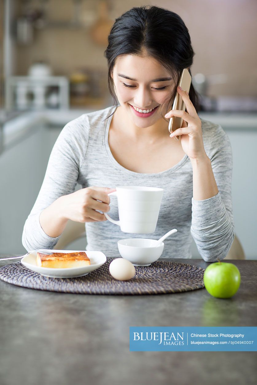 Young Chinese woman eating breakfast at home-High-res stock photo for ...