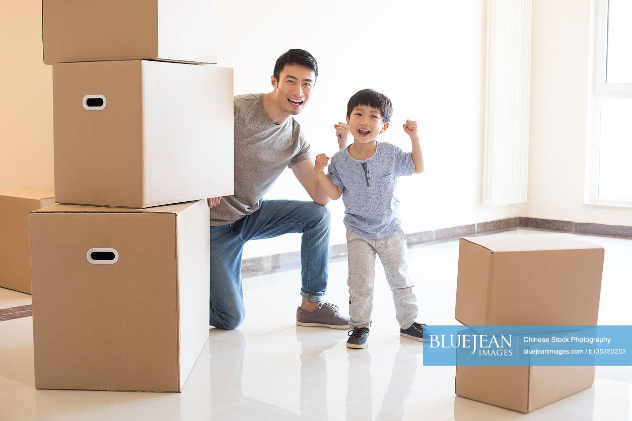 Happy young Chinese father and son moving home-High-res stock photo for ...
