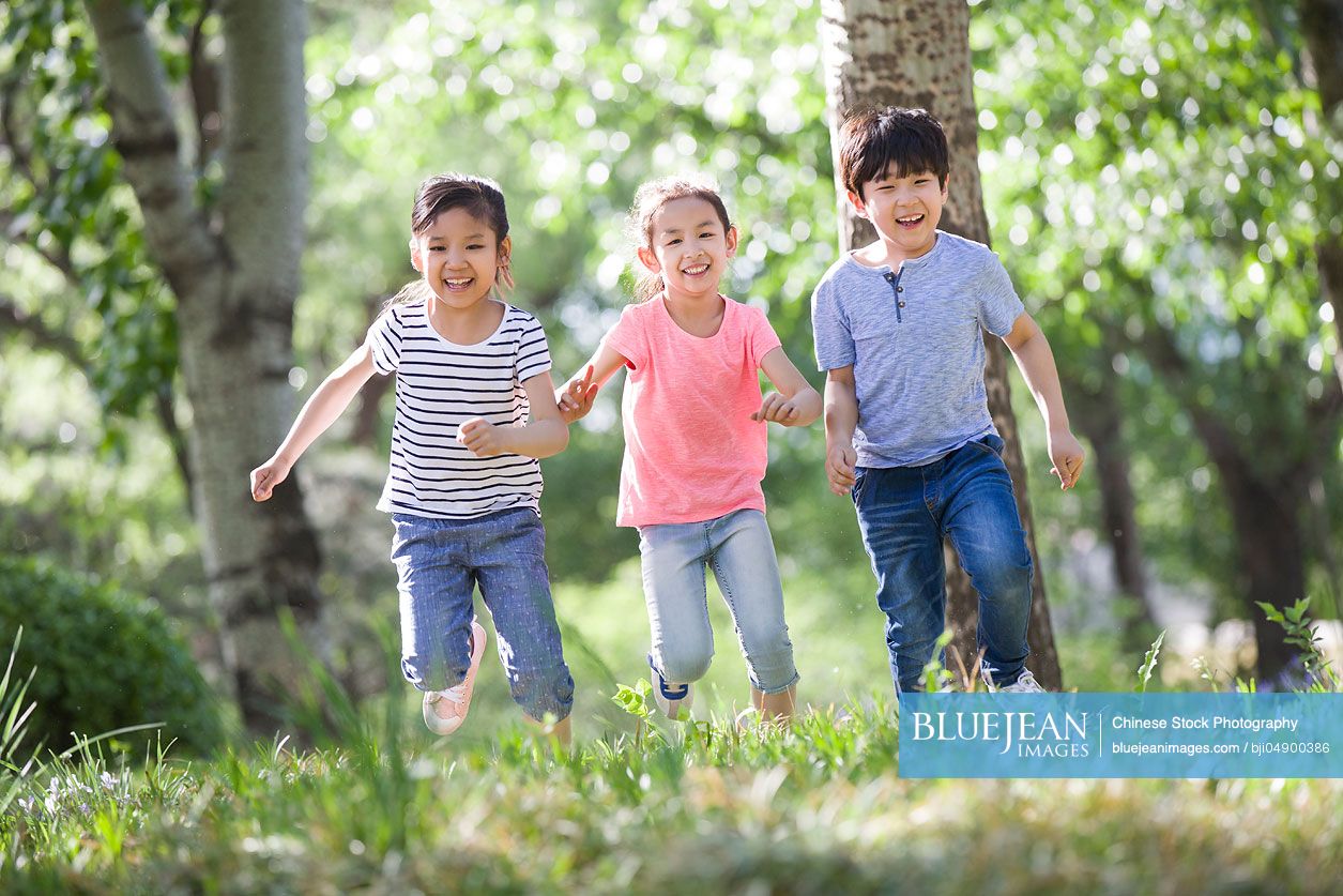 Happy Chinese children racing in woods-High-res stock photo for download