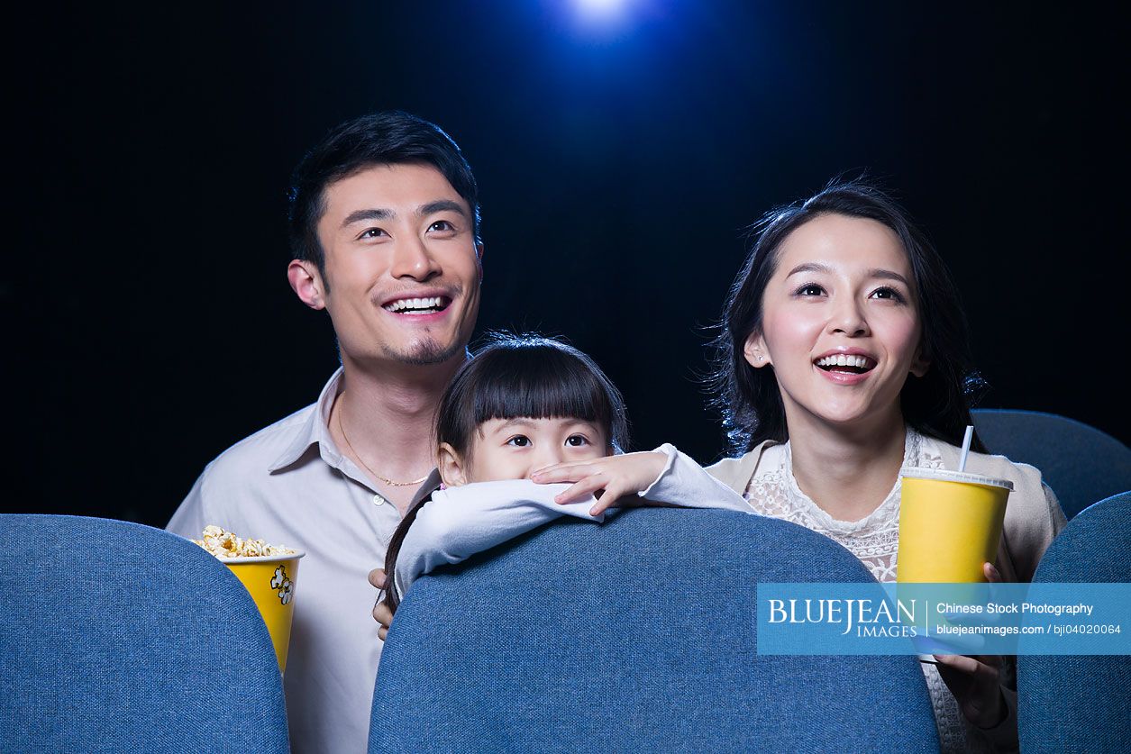 Young Chinese family watching movie in cinema-High-res stock photo for ...