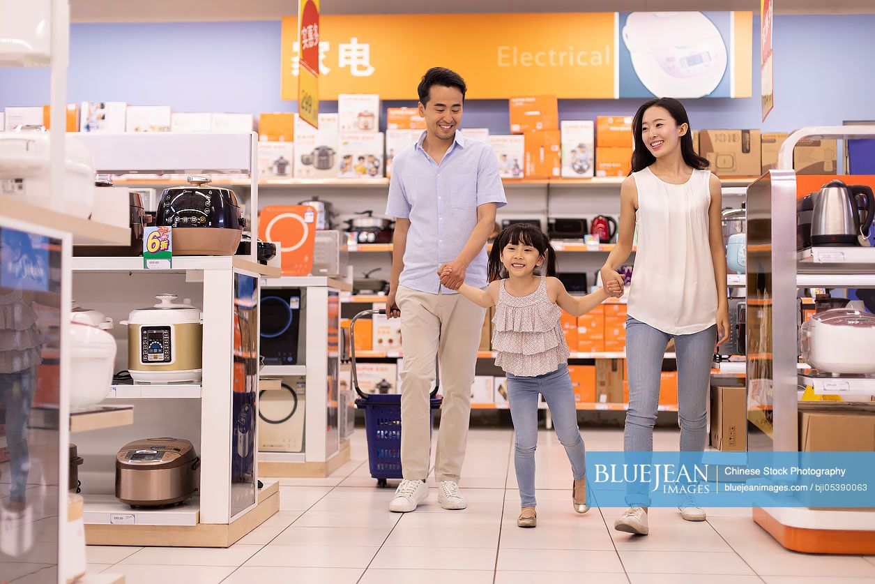 Happy young Chinese family shopping in supermarket-High-res stock photo ...