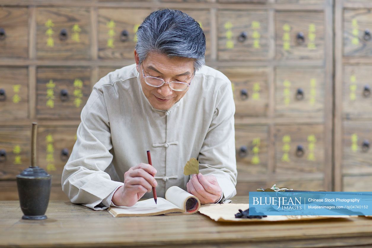 Senior Chinese doctor checking medicinal herbs-High-res stock photo for ...