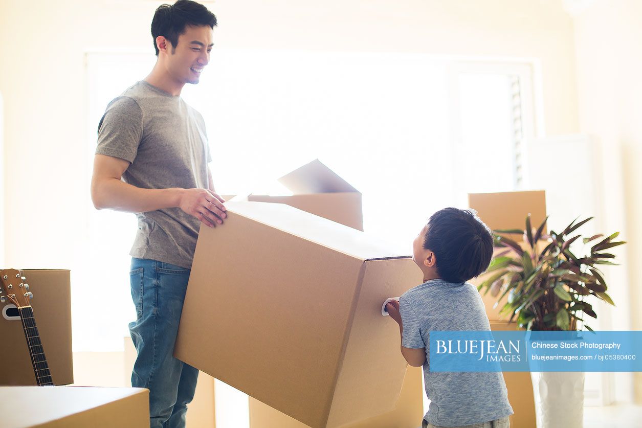 Happy young Chinese father and son moving home-High-res stock photo for ...
