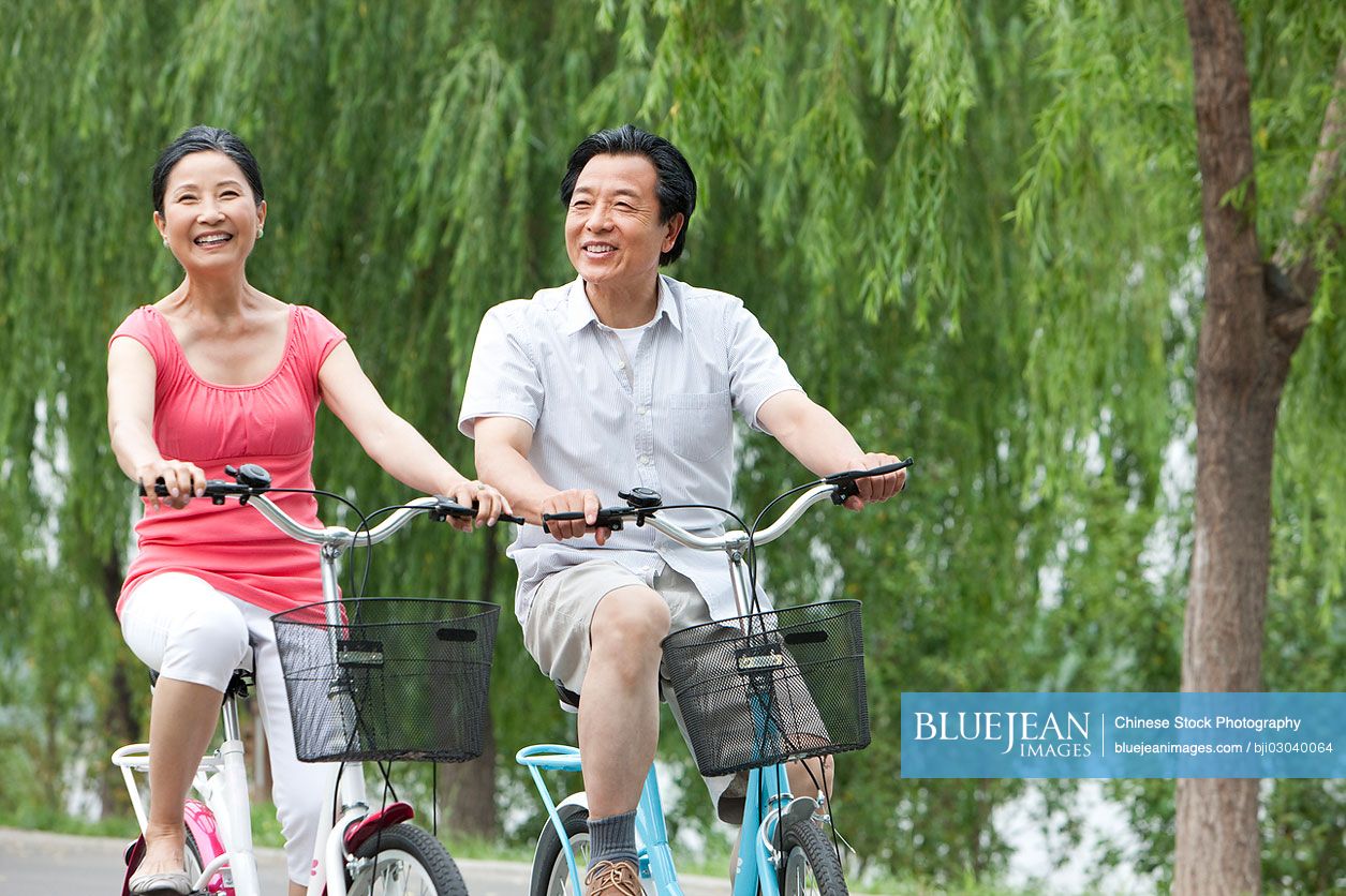 Senior Chinese couple cycling in park-High-res stock photo for download