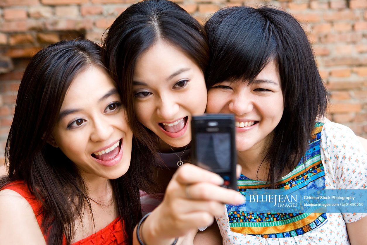 Chinese friends taking photos with mobile phone-High-res stock photo ...