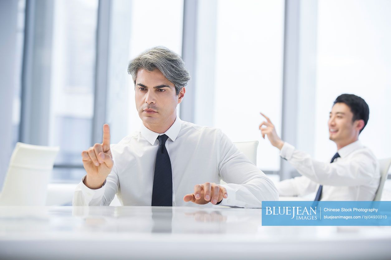 Business people using advanced touch screen technology in office-High ...