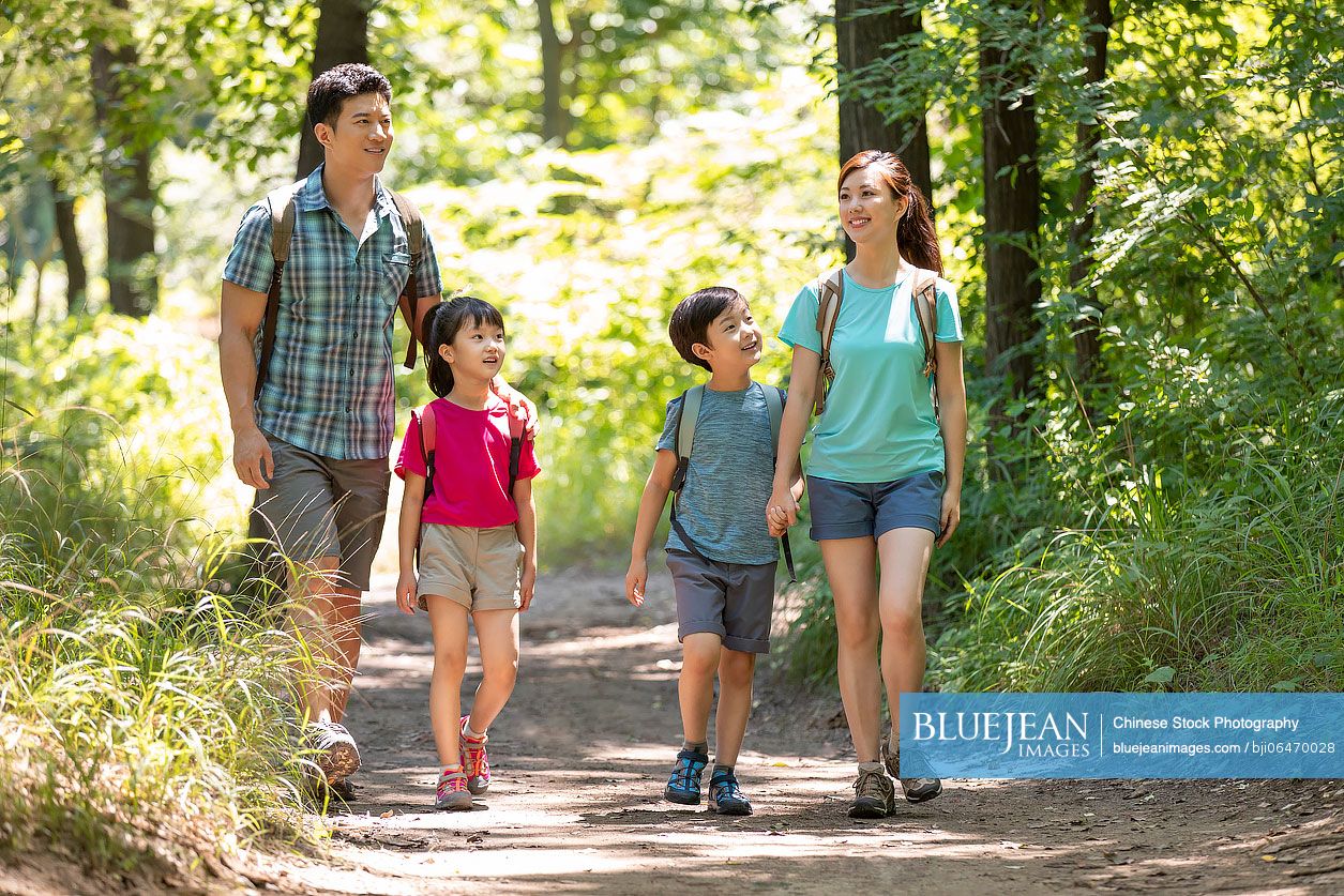 Happy young Chinese family hiking outdoors-High-res stock photo for download