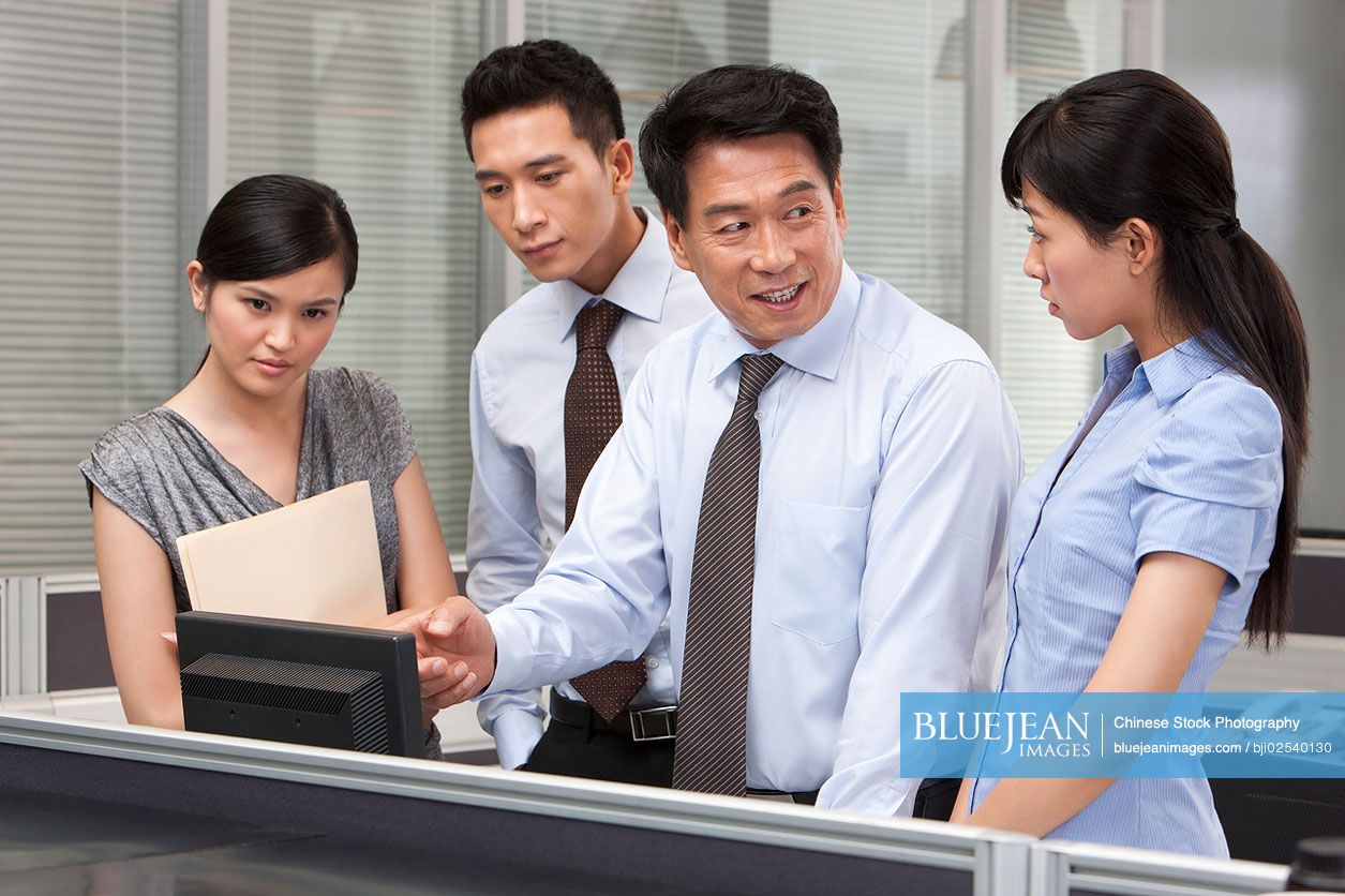 Senior Chinese colleague helping co-workers-High-res stock photo for ...