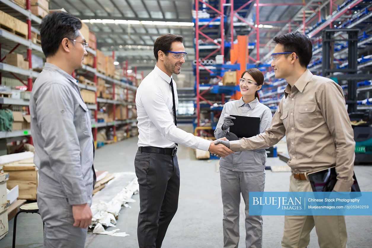 Businessman shaking hands with engineer in the factory-High-res stock photo for download