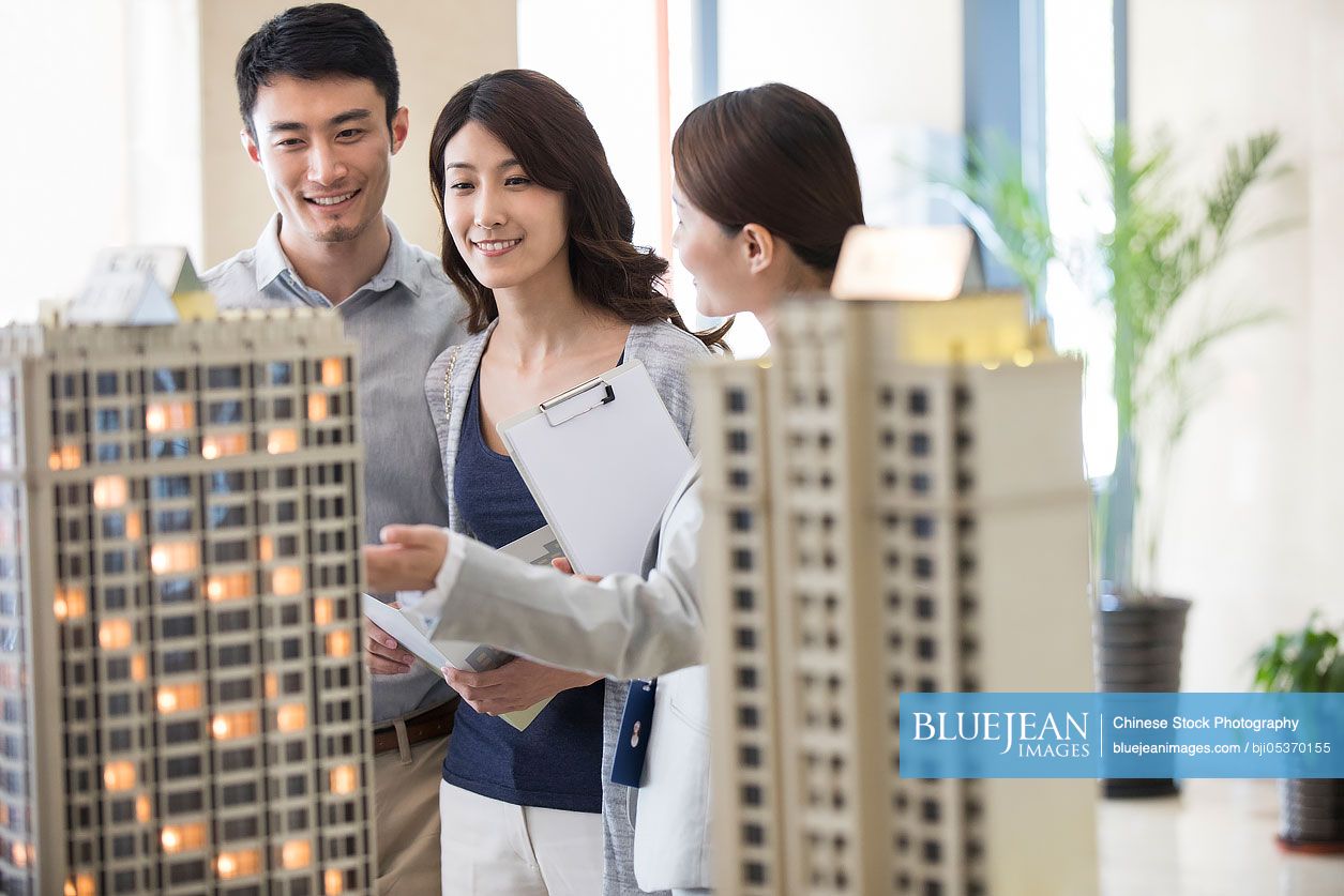 Happy young Chinese couple buying new house from sales center-High-res ...