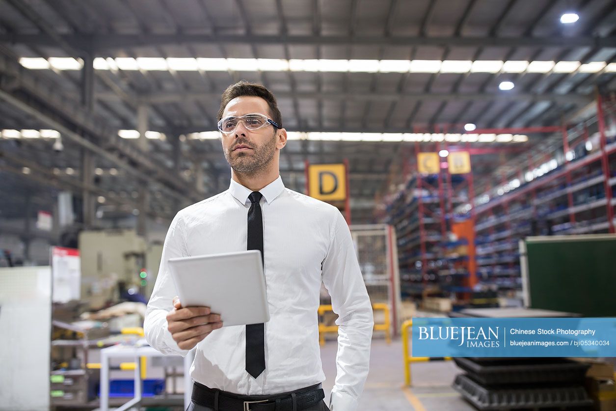 Businessman holding a digital tablet in the factory-High-res stock ...
