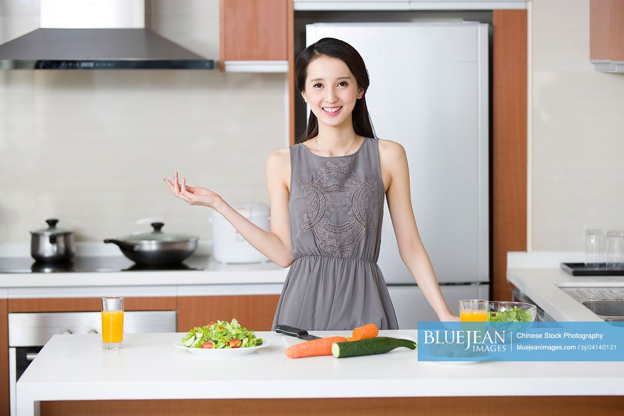 Young Chinese woman cooking in the kitchen-High-res stock photo for ...