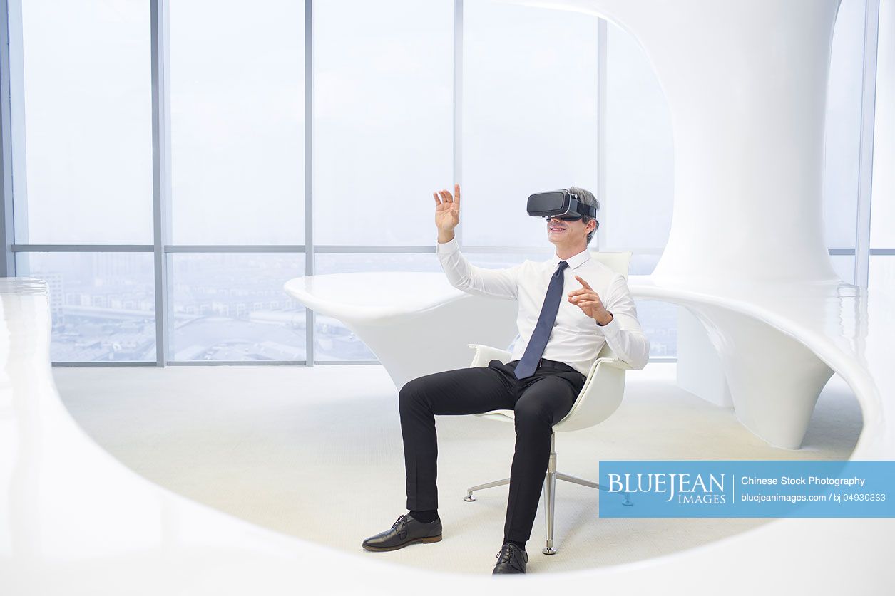 Businessman wearing VR glasses in office-High-res stock photo for download