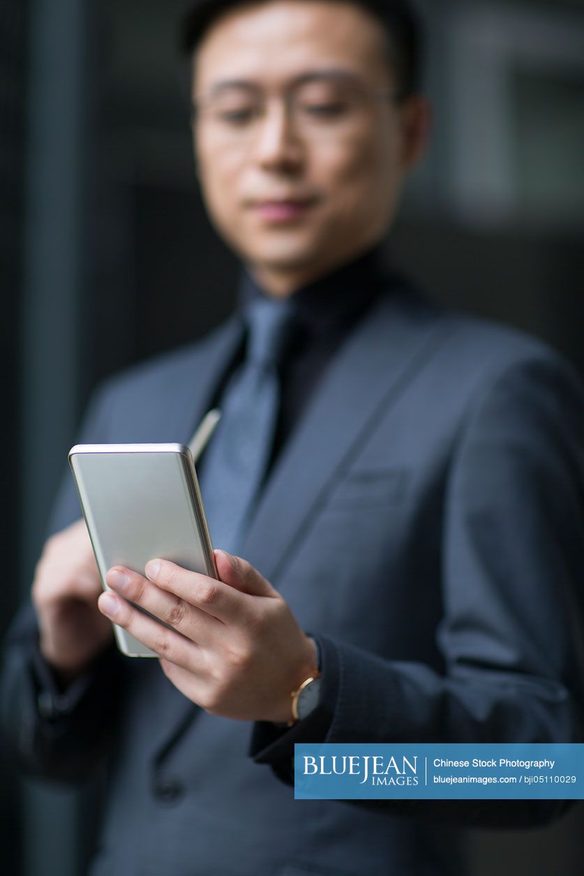 Mid adult Chinese businessman using smart phone-High-res stock photo ...