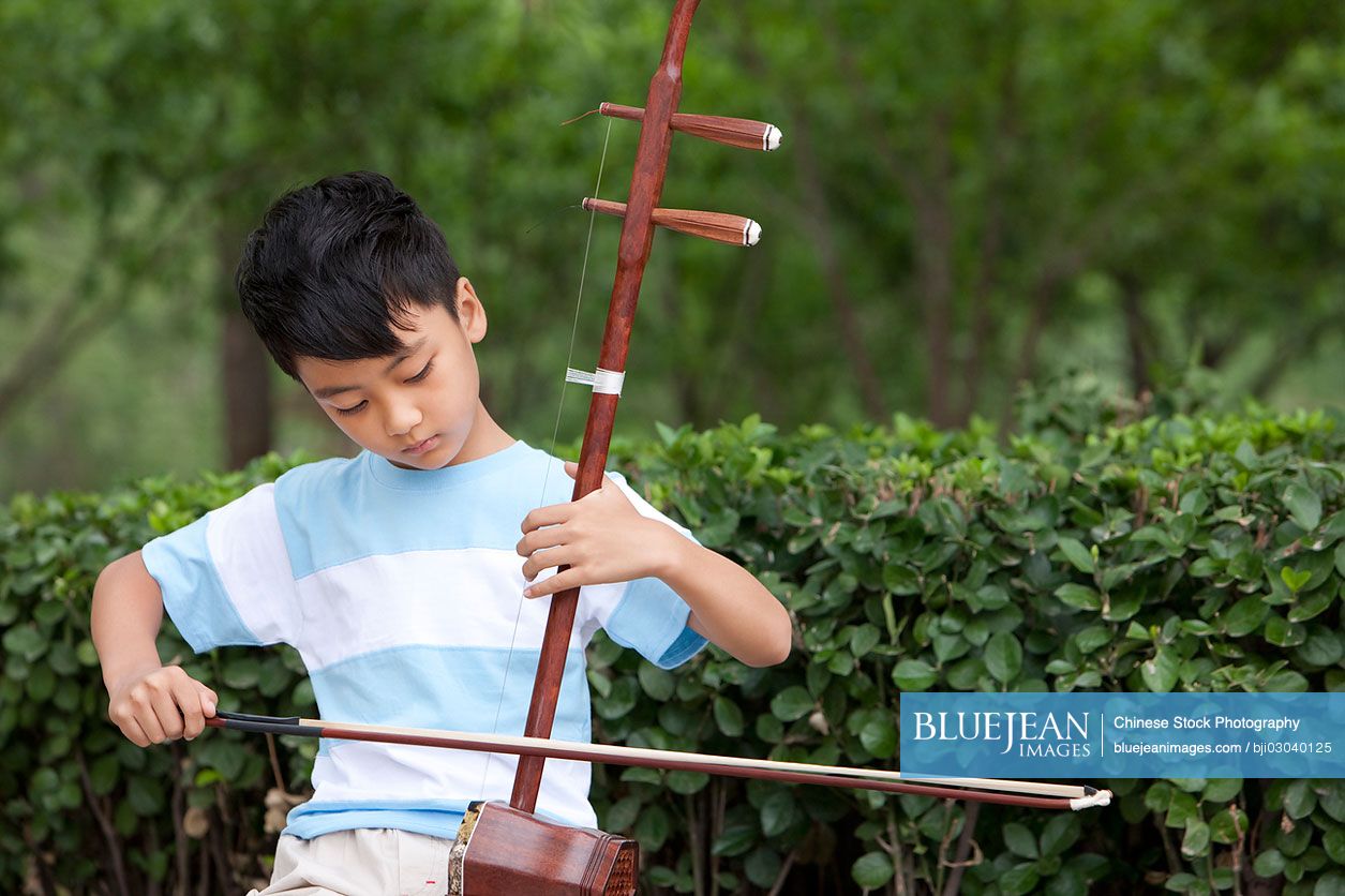 Chinese boy playing traditional musical instrument Erhu-High-res stock ...
