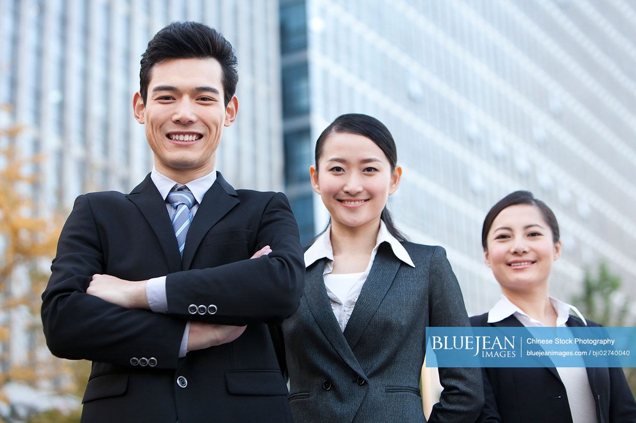 A team of Chinese businesspeople outside office buildings-High-res ...