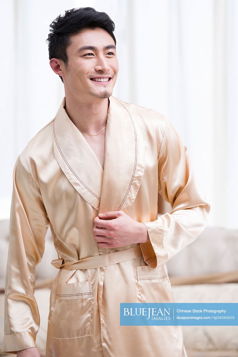 Cheerful young Chinese man in bedroom-High-res stock photo for download