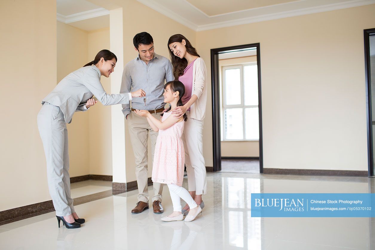 Chinese realtor giving young family keys to new house-High-res stock photo for download
