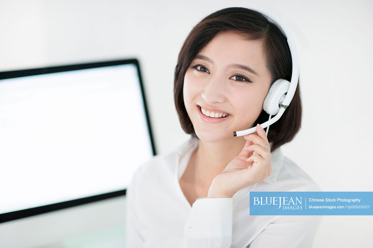 Cheerful Chinese businesswoman with headset in office-High-res stock photo for download