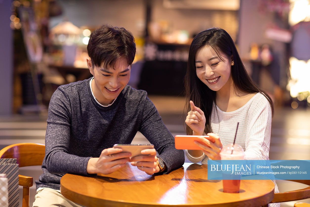 Happy young Chinese couple playing mobile games-High-res stock photo ...