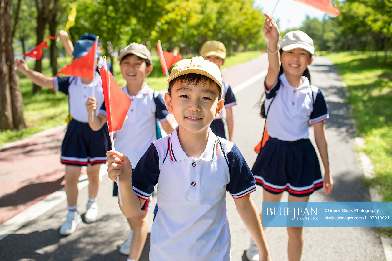 Cheerful Chinese school children relaxing in park-High-res stock photo for download