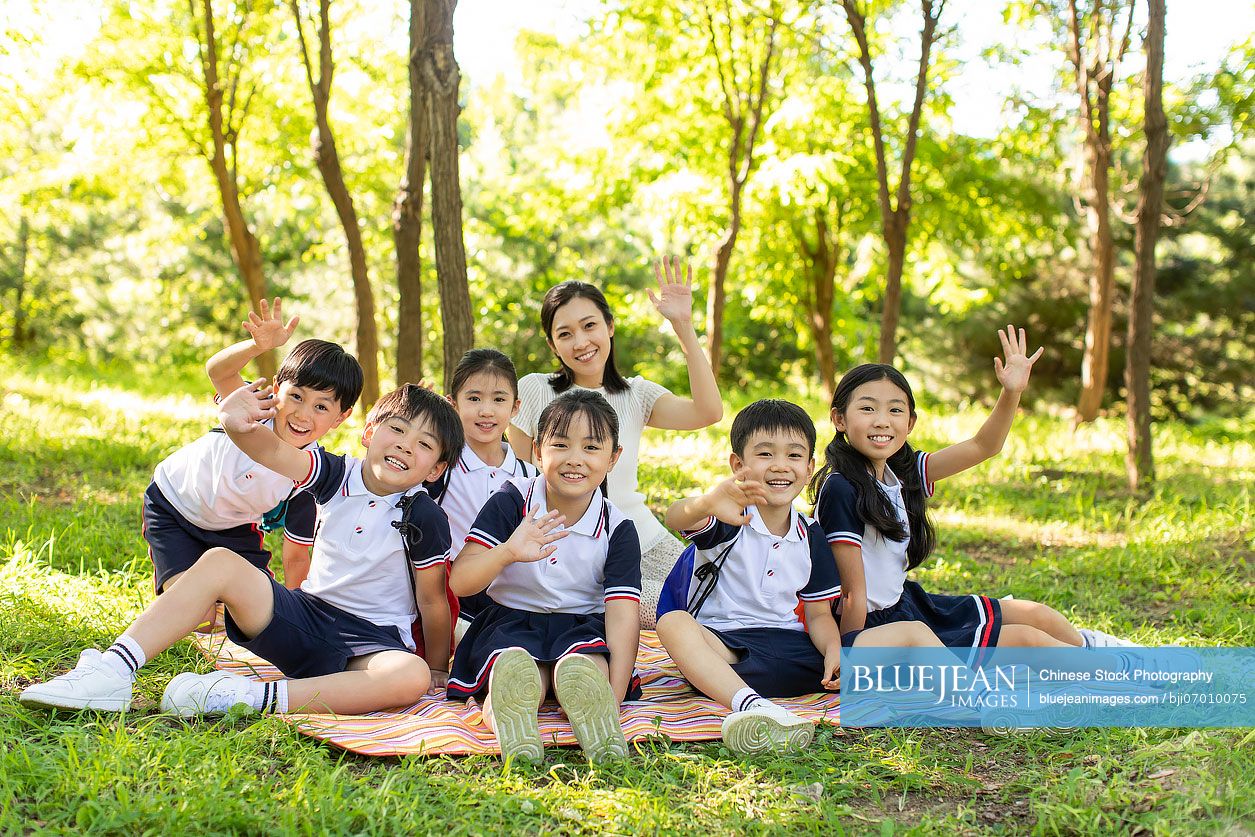 Cheerful Chinese school children picnicking outdoors with their teacher-High-res stock photo for ...