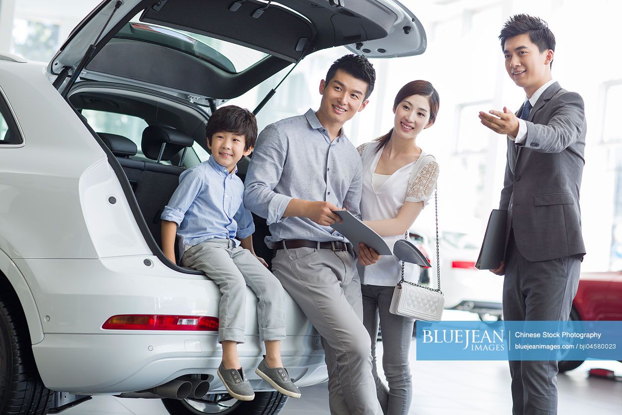 Young Chinese family choosing car in showroom-High-res stock photo for ...